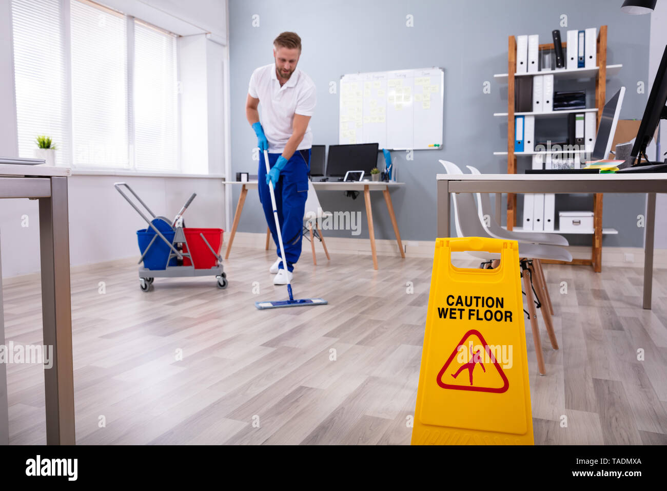 Male janitor with mop cleaning modern office floor Stock Photo - Alamy