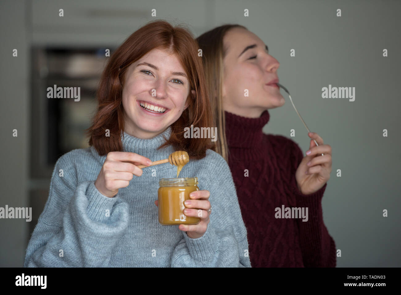 Two best friends tasting honey in the kitchen Stock Photo - Alamy