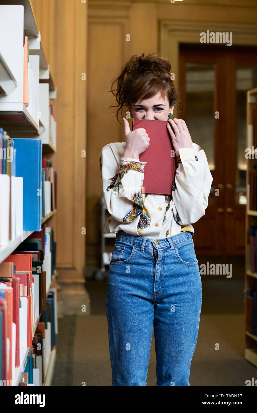 Female student reading book in a public library Stock Photo - Alamy