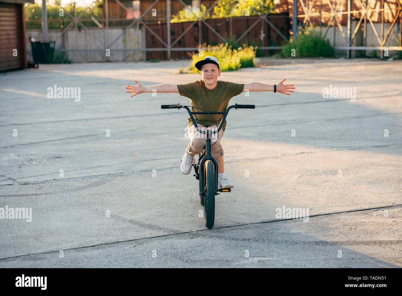 Portrait of smiling boy riding bmx bike freehanded Stock Photo - Alamy