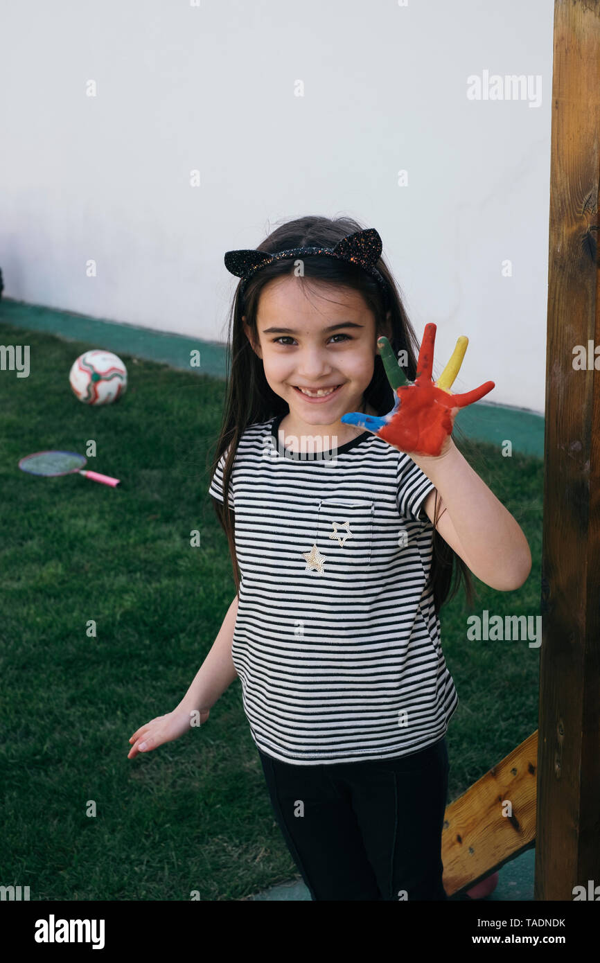 Girl smiling and showing her painted palm Stock Photo - Alamy