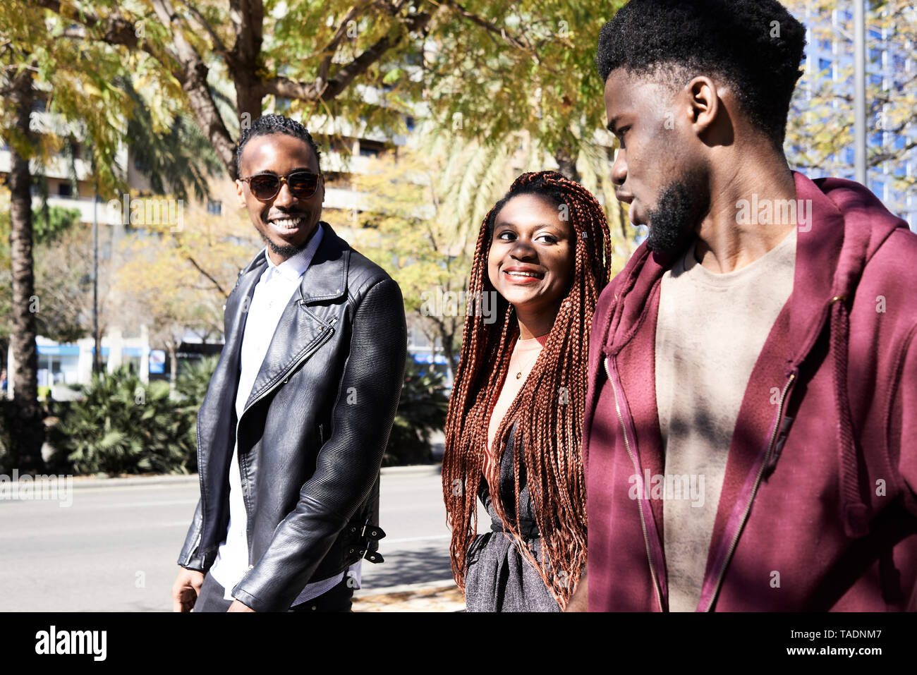 Three happy friends on the go in the city Stock Photo - Alamy