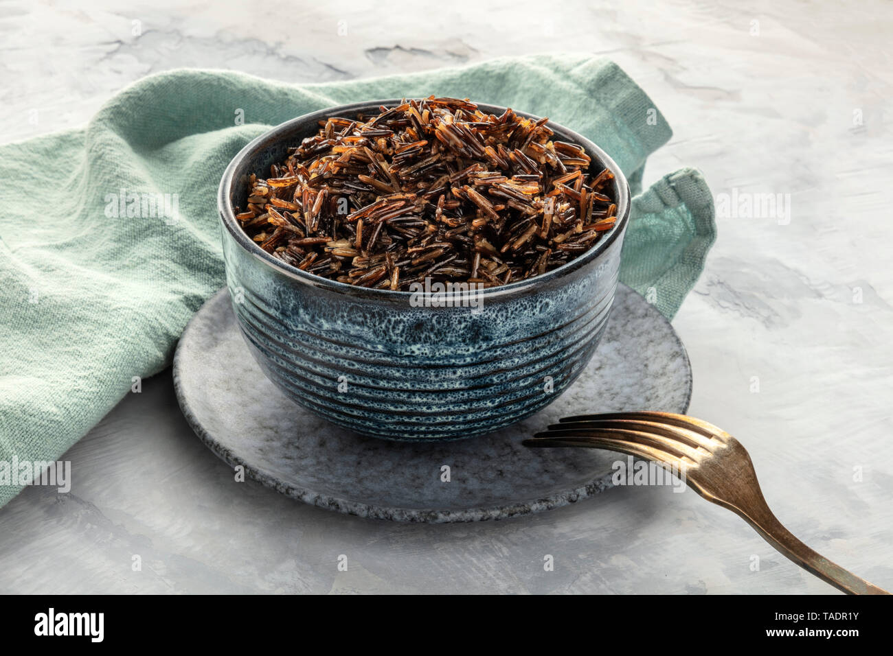 Cooked wild black rice in a bowl, with a fork and a place for text ...