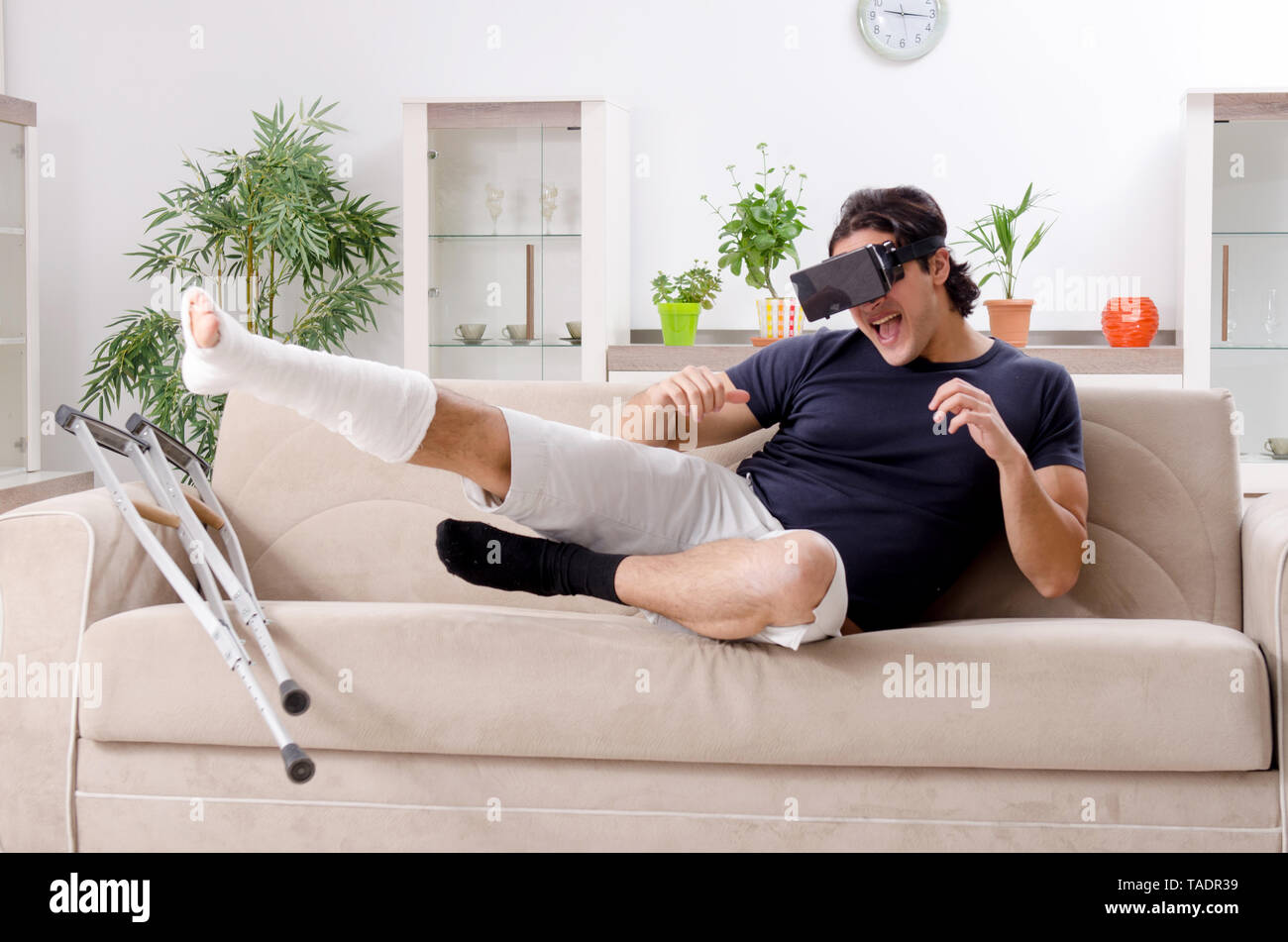 Leg injured young man suffering at home Stock Photo - Alamy