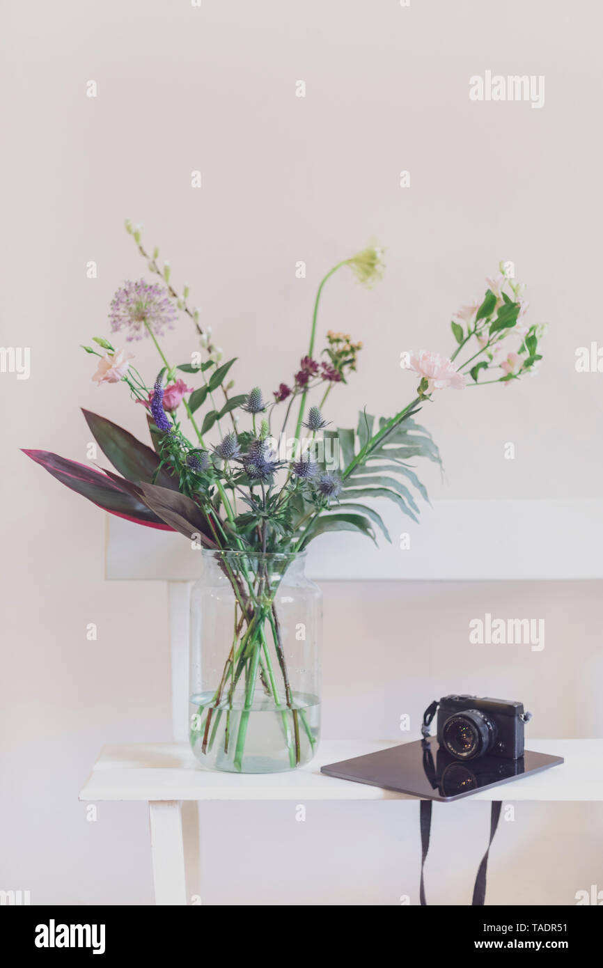 Flower vase and open calendar on white bench, camera and tablet Stock ...