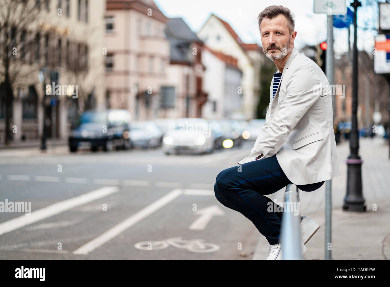 Portrait of mature man sitting on railing in the city hi-res stock ...