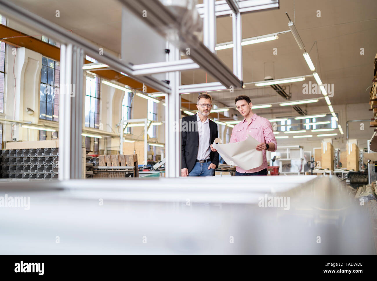 Two men with plan in a factory Stock Photo - Alamy