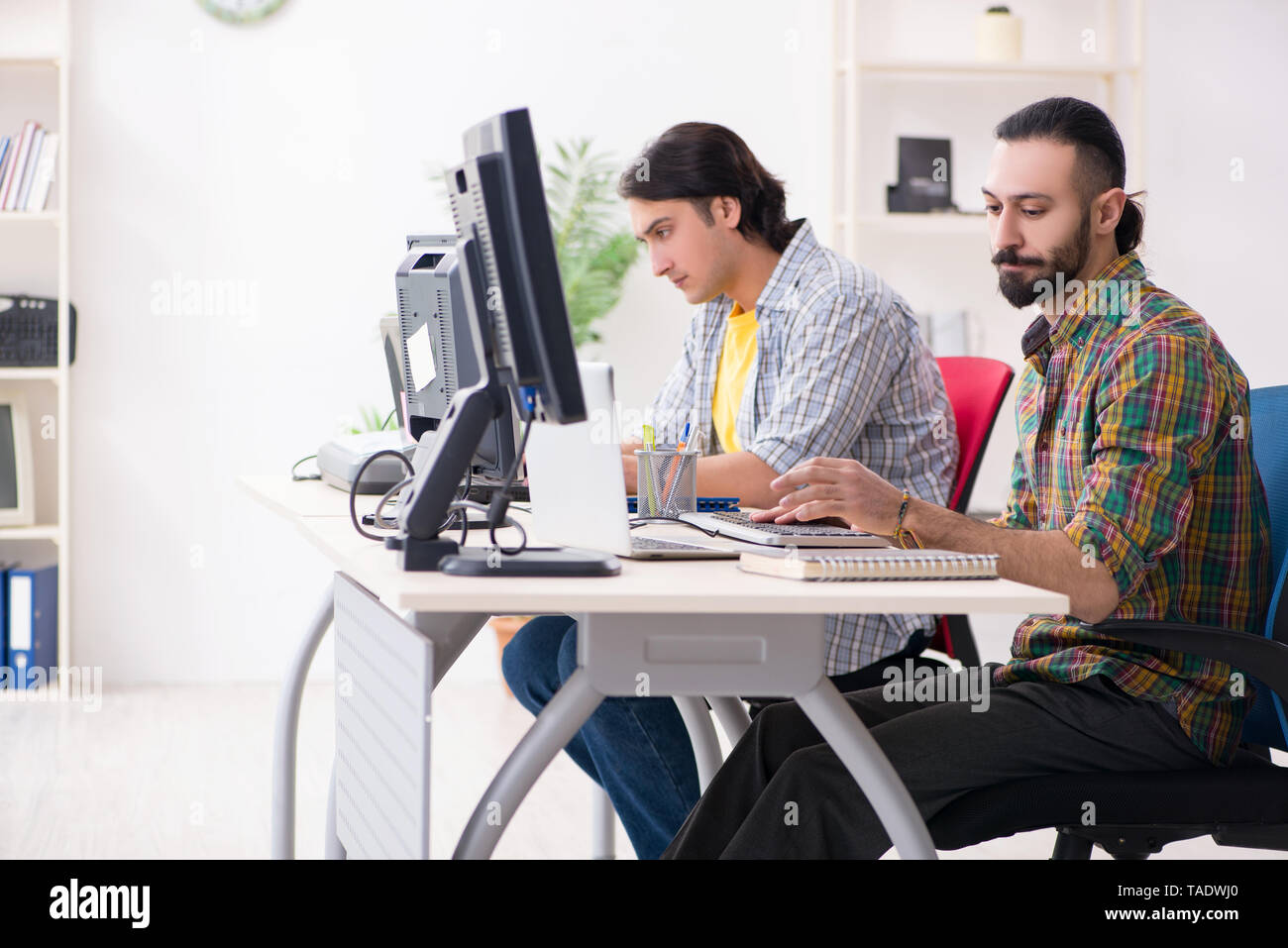 Two it specialists working in the office Stock Photo - Alamy