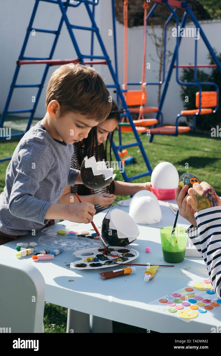 Friends painting Easter eggs in garden Stock Photo - Alamy