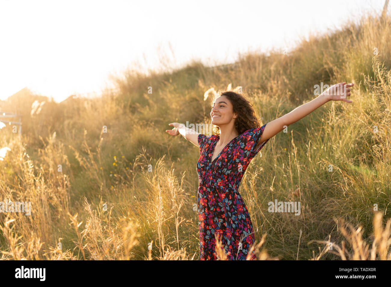 Happy young woman standing in summer meadow Stock Photo - Alamy