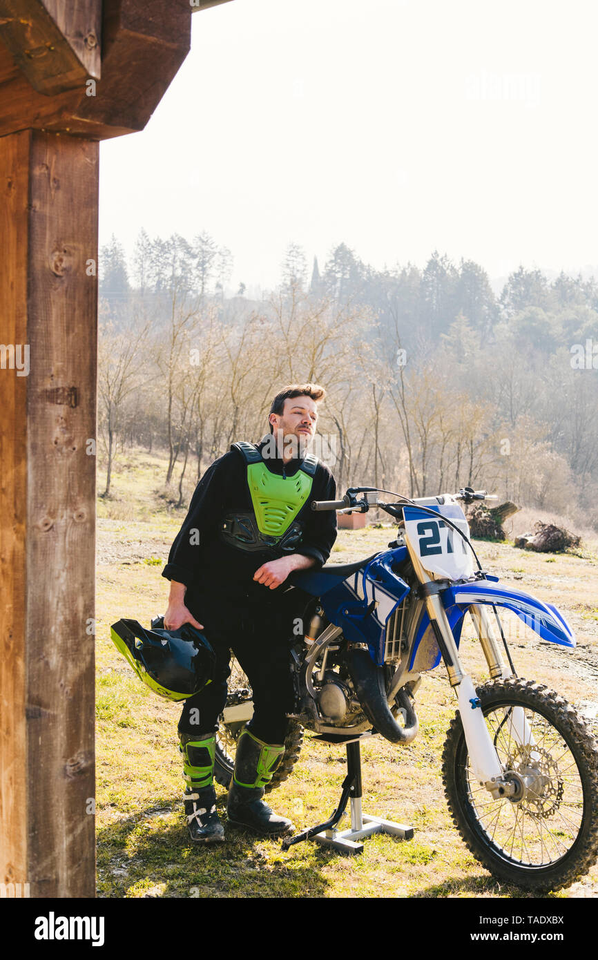 Motocross driver with jacked up motorbike Stock Photo - Alamy