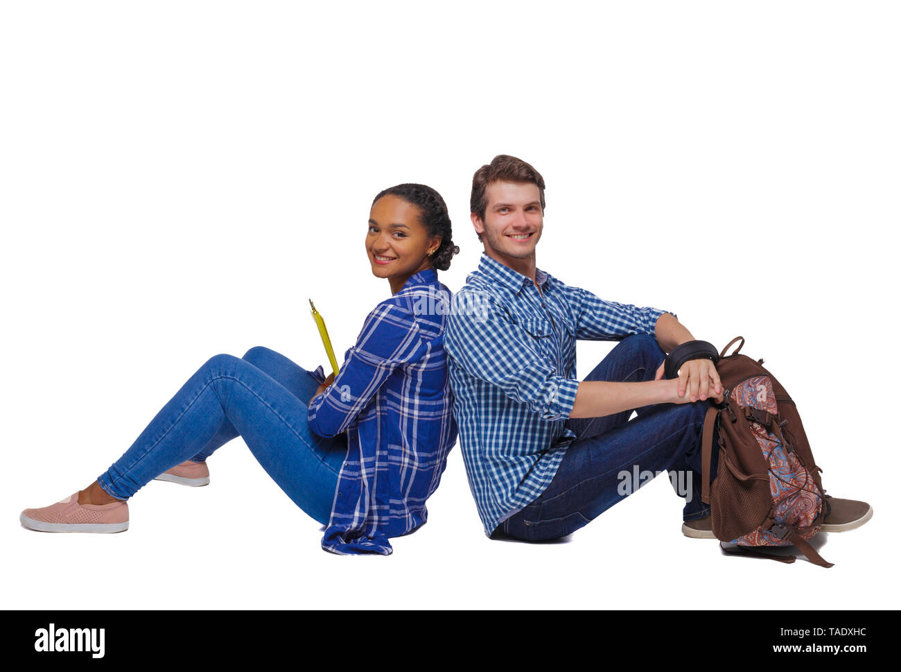 Side view of a couple of students who are sitting on the floor with ...
