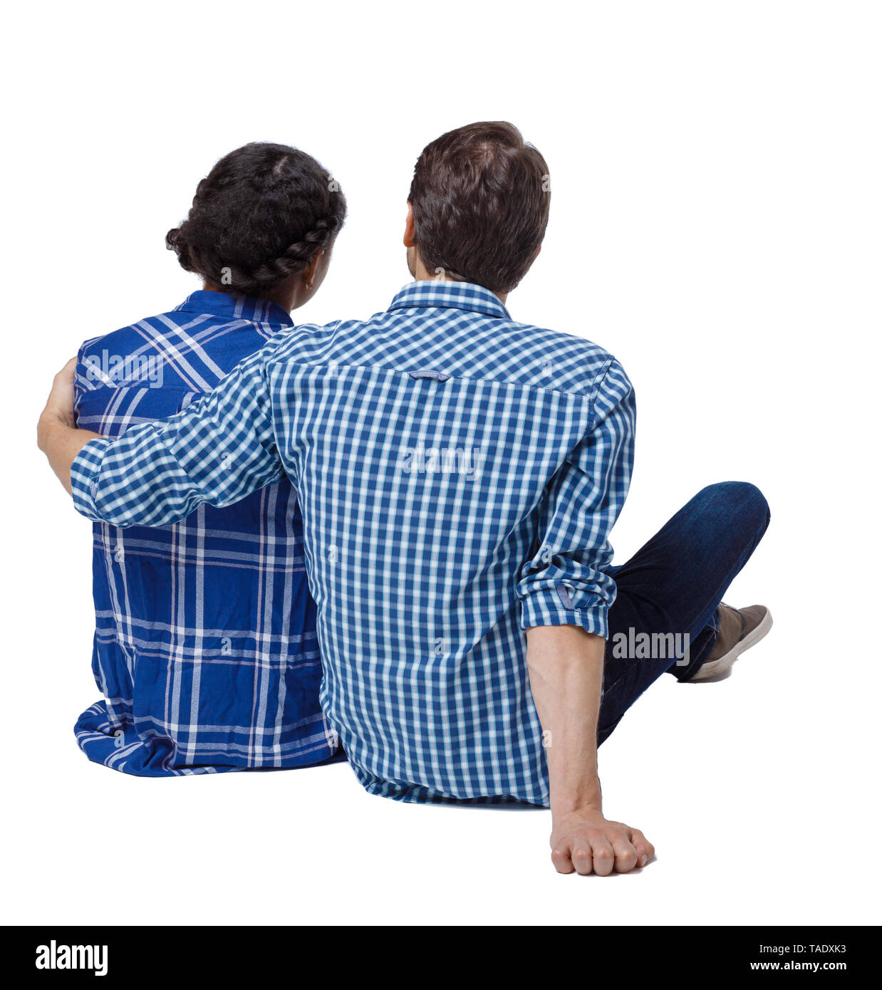 Back view of a multiethnic young couple sitting on the ground and ...