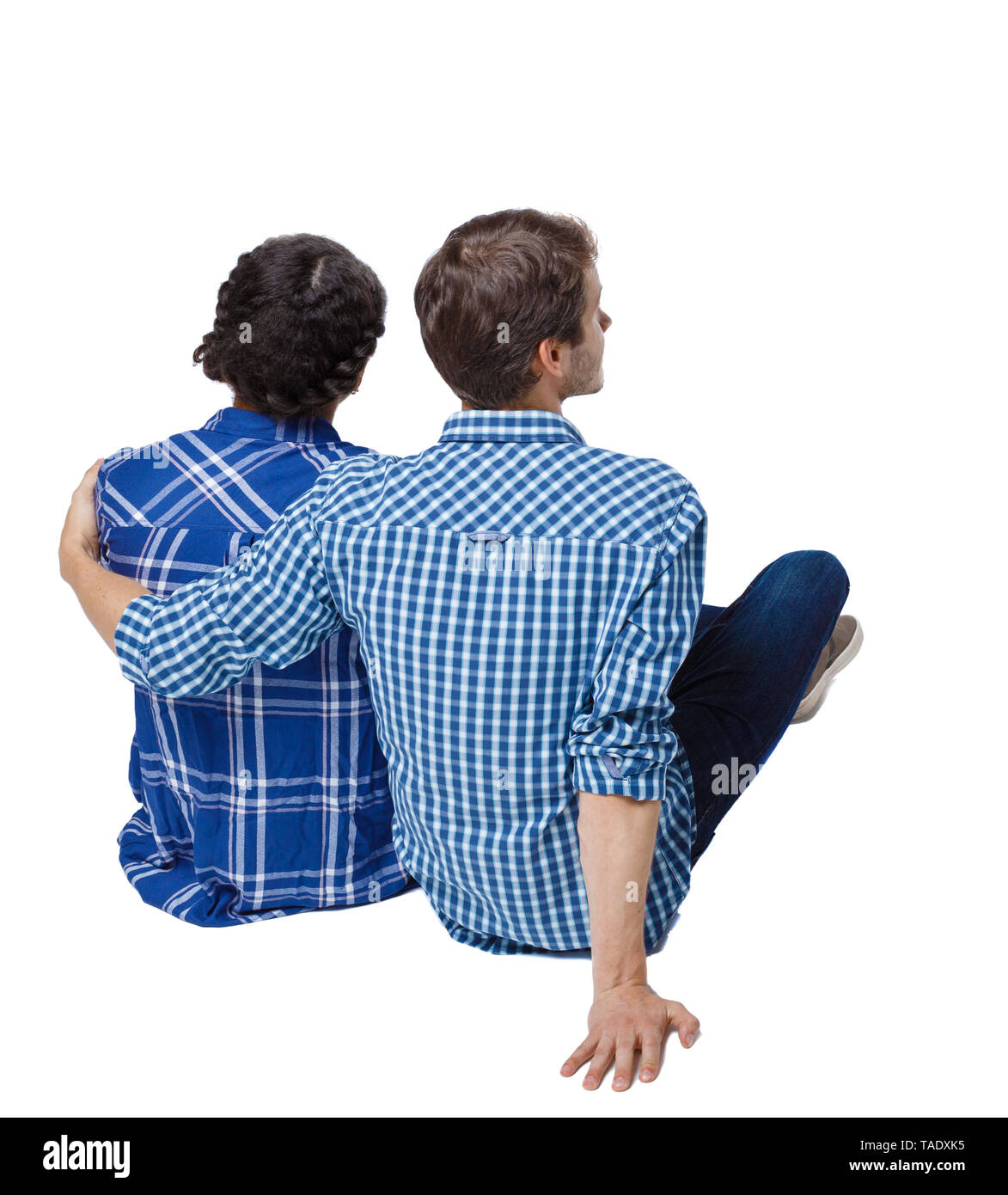 Back view of a multiethnic young couple sitting on the ground and ...