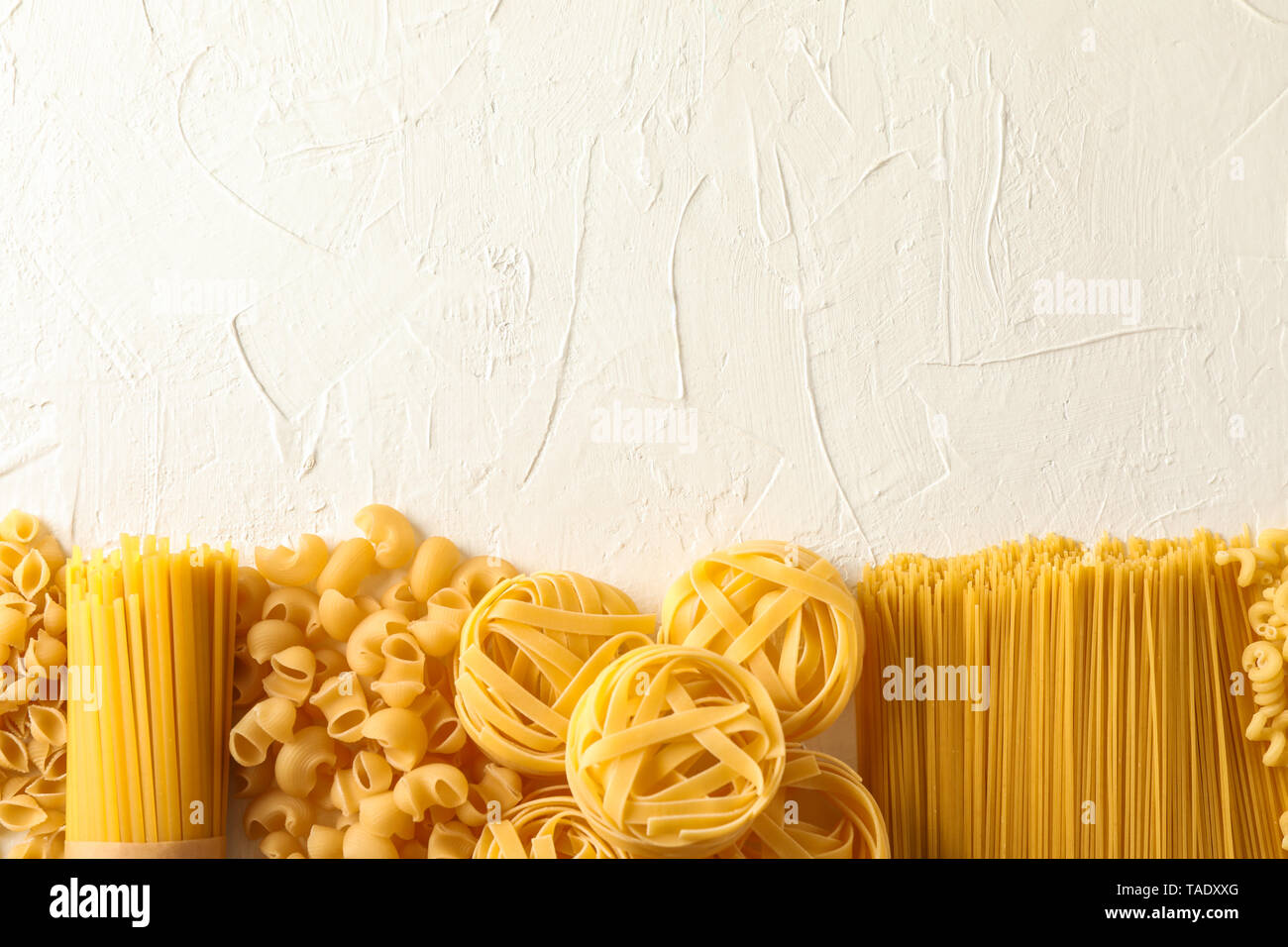Different pasta on white background, space for text. Dry uncooked whole ...