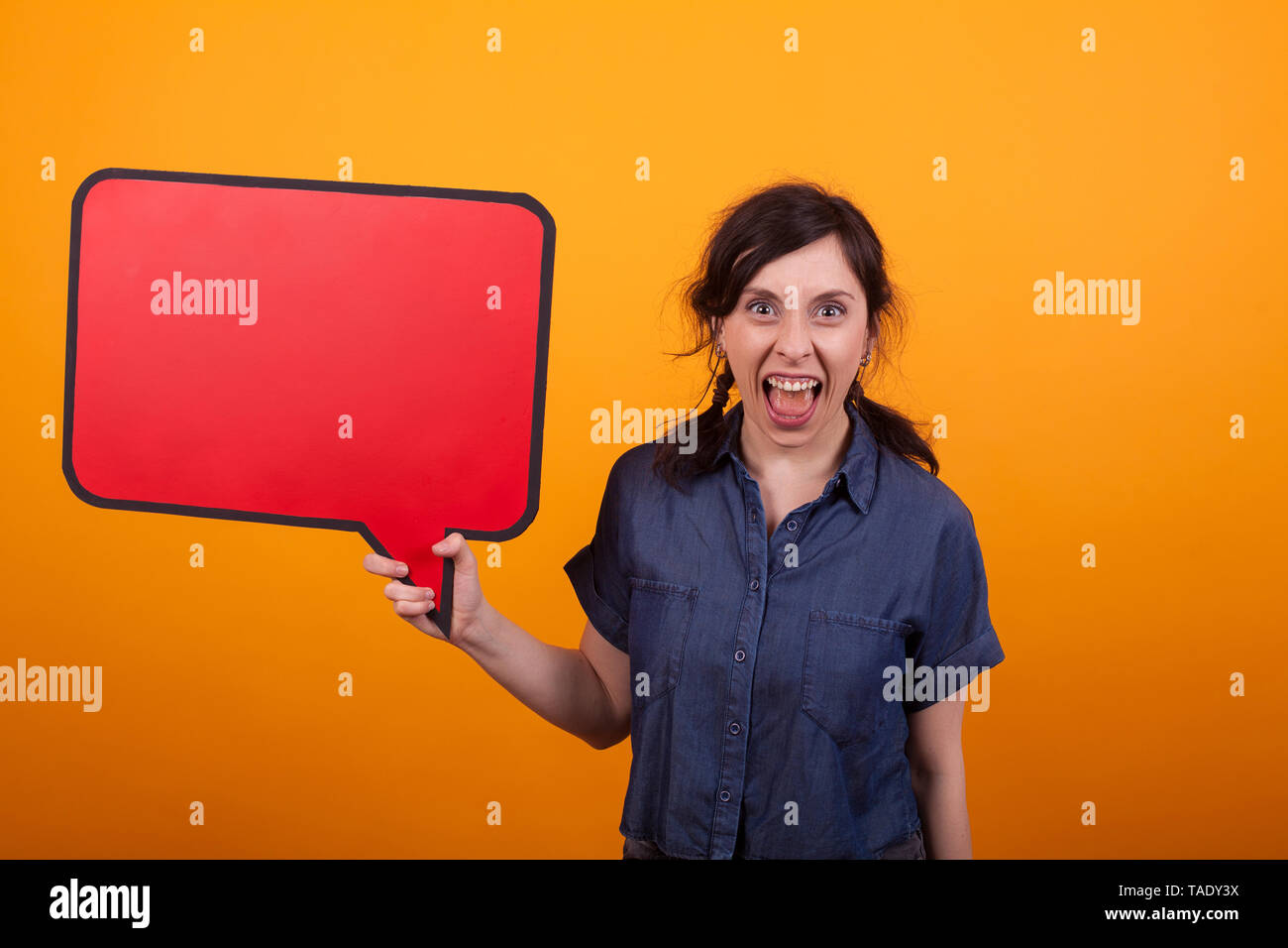 Portrait of screaming beautiful woman with thoughts bubble in her hand ...