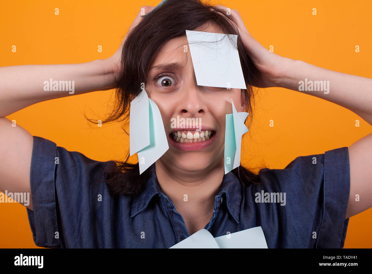 Portrait of beautiful woman frustrated with sticky notes on forehead in ...