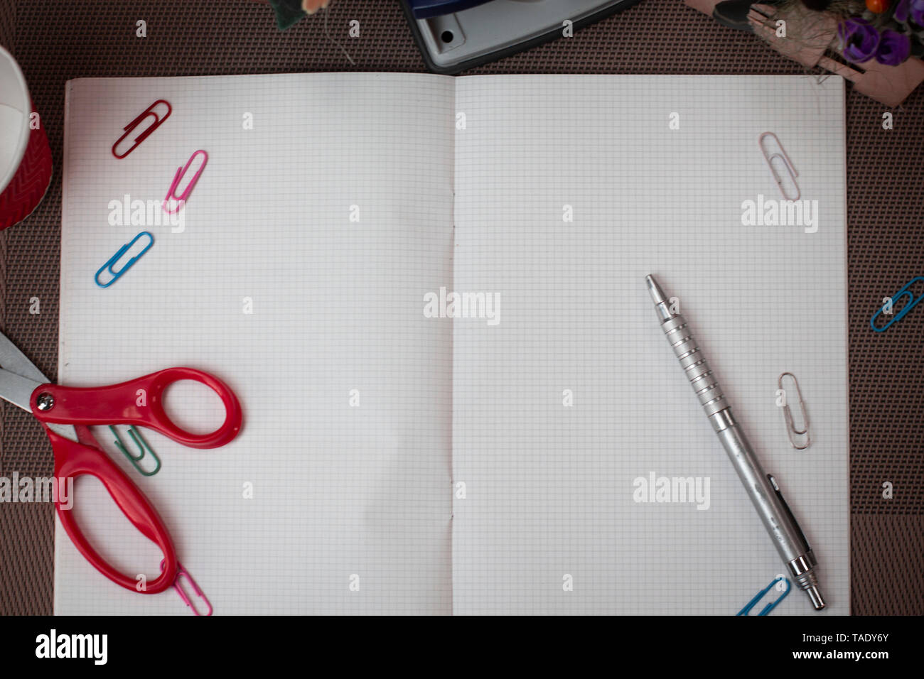 Scissors and writing equipments plus math book above textured backdrop ...