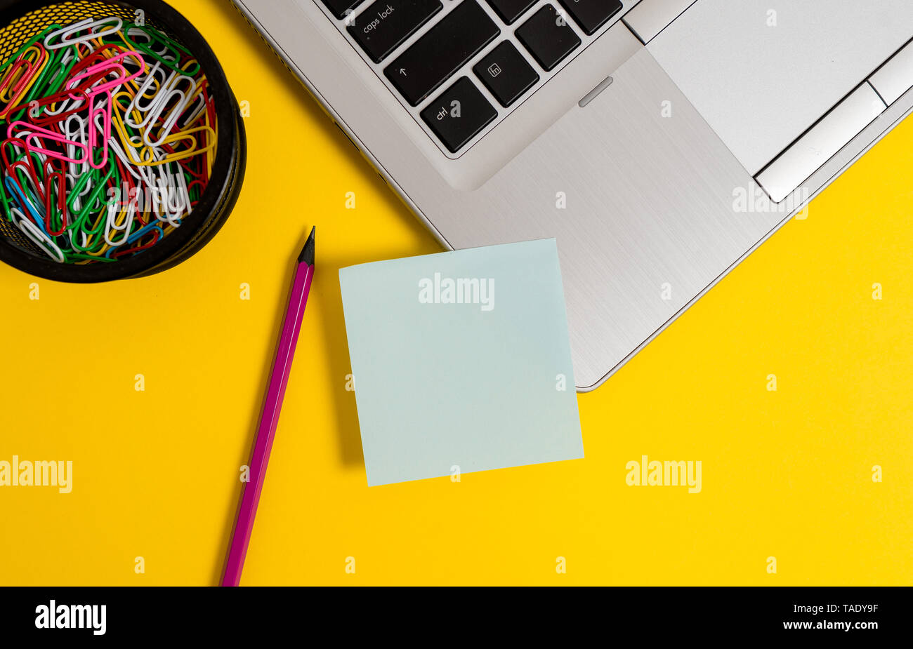 Metallic laptop sticky note clips container pencil colored background ...