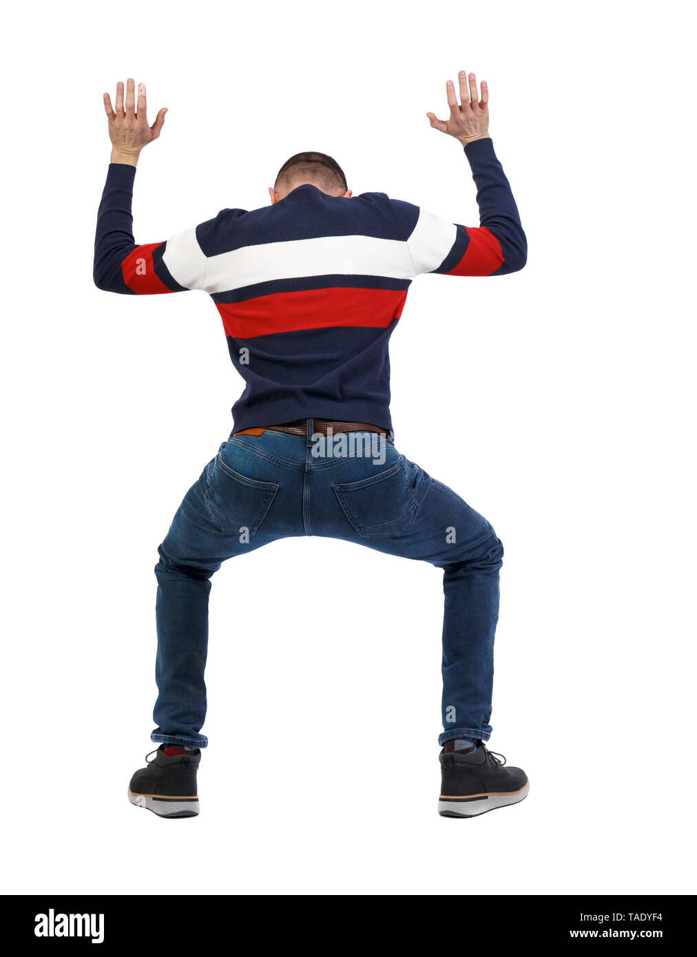back view. man protects hands from what is falling from above. Man ...
