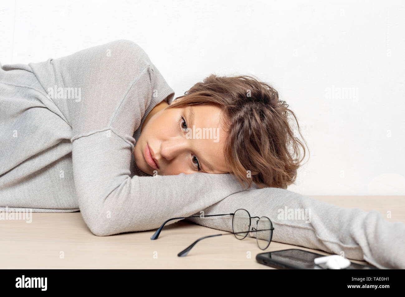 Portrait of sad young woman lying on the floor Stock Photo - Alamy