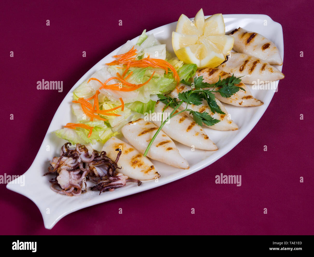 Small squid (baby squid) grilled with salad Stock Photo - Alamy