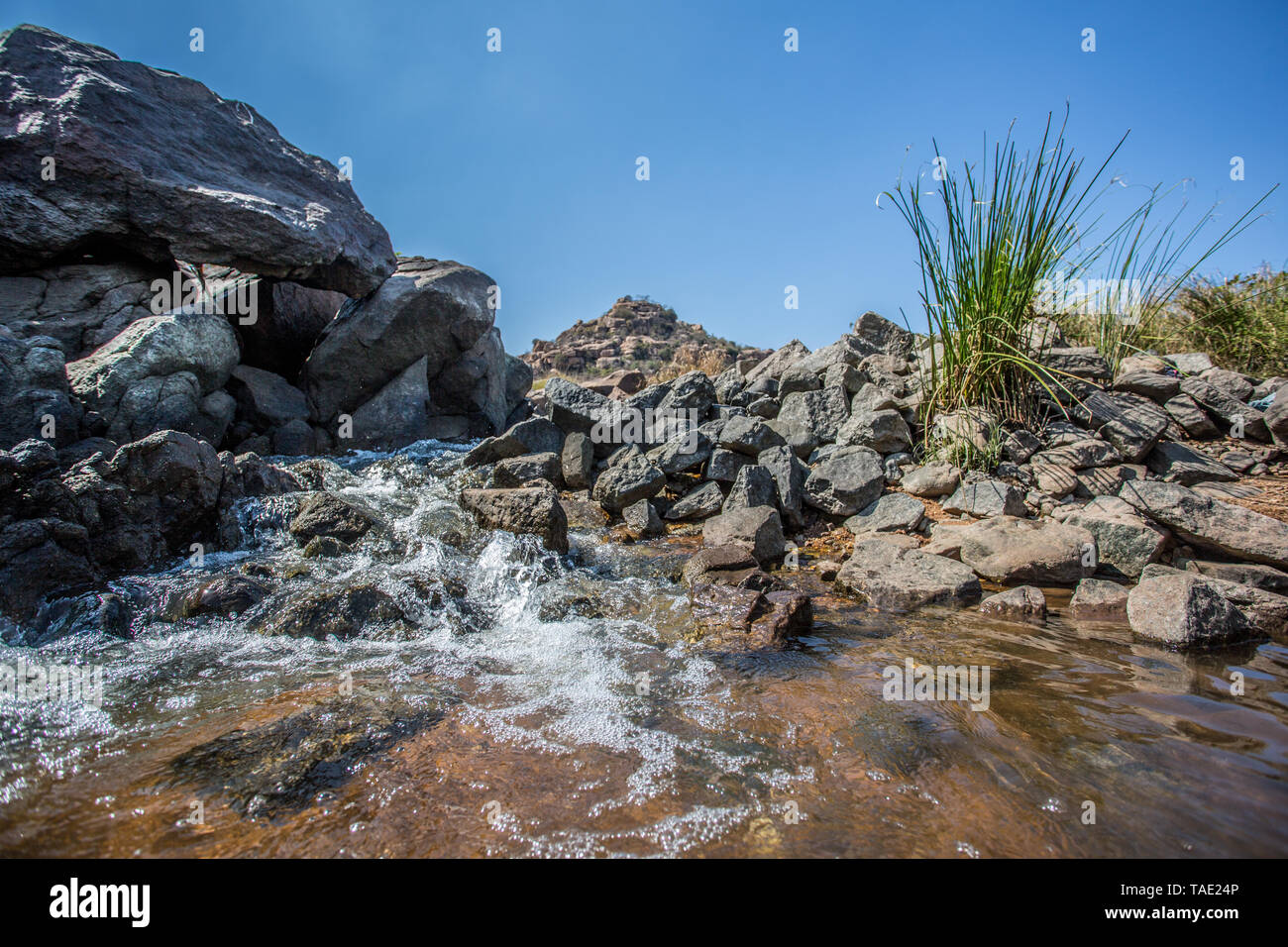 Water flowing from a river over some rocks in Hampi, India Stock Photo ...