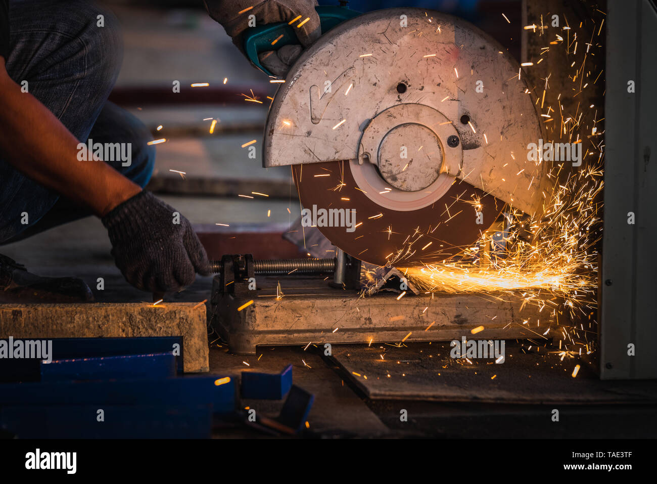 Industrial worker cutting metal with many sharp sparks. Selection focus ...