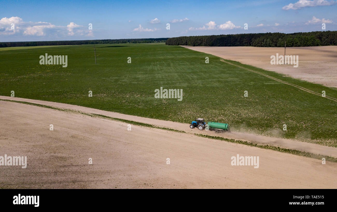 Tractor driven organic fertilizer on the field Stock Photo - Alamy