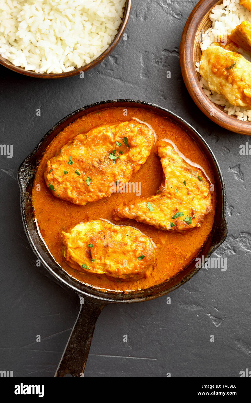 Fish curry in pan on black stone table. Indian style food. Top view ...
