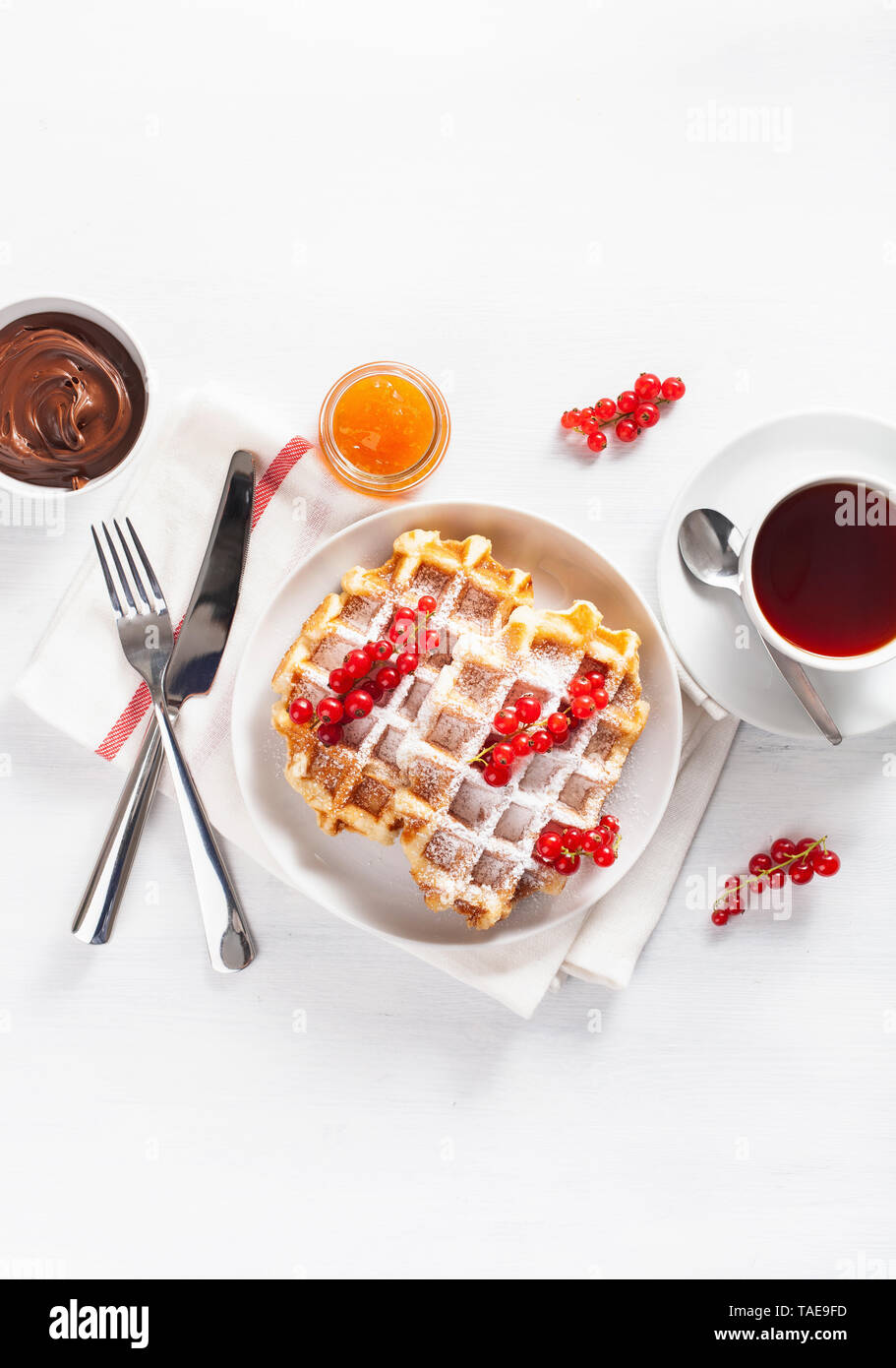 breakfast waffle with berry, jam, chocolate spread and tea. Top view ...