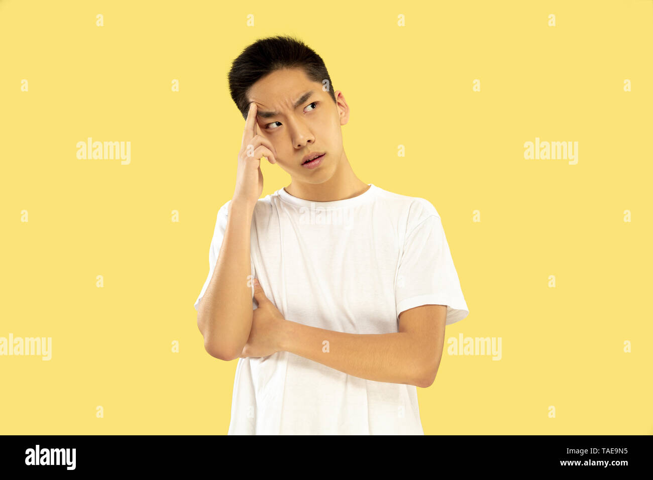Korean young man's half-length portrait on yellow studio background ...