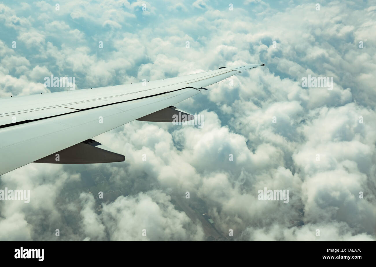 Wing of plane over white clouds. Airplane flying on blue sky. Scenic ...
