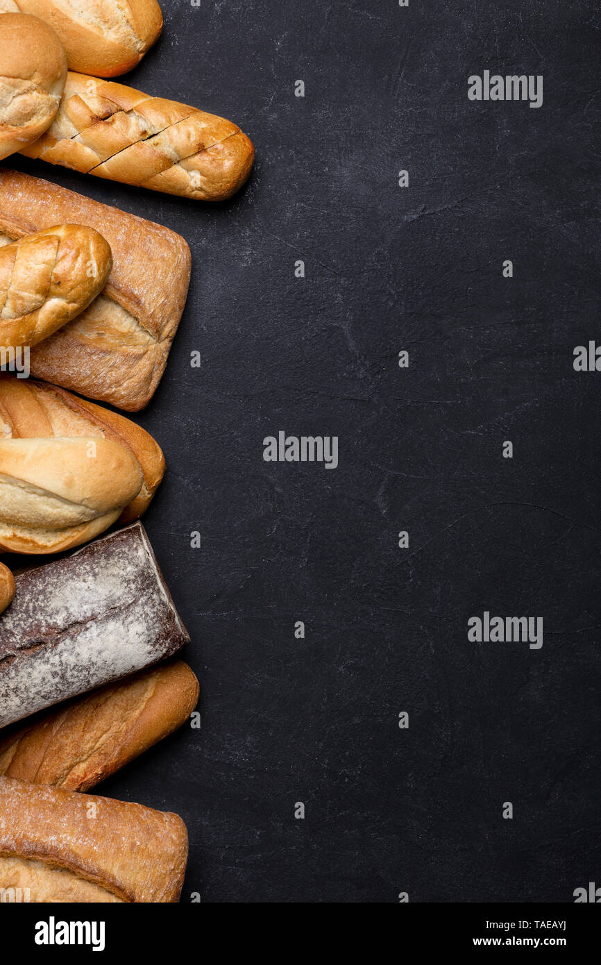 Fresh breads on dark background. Free space for text, top view with ...
