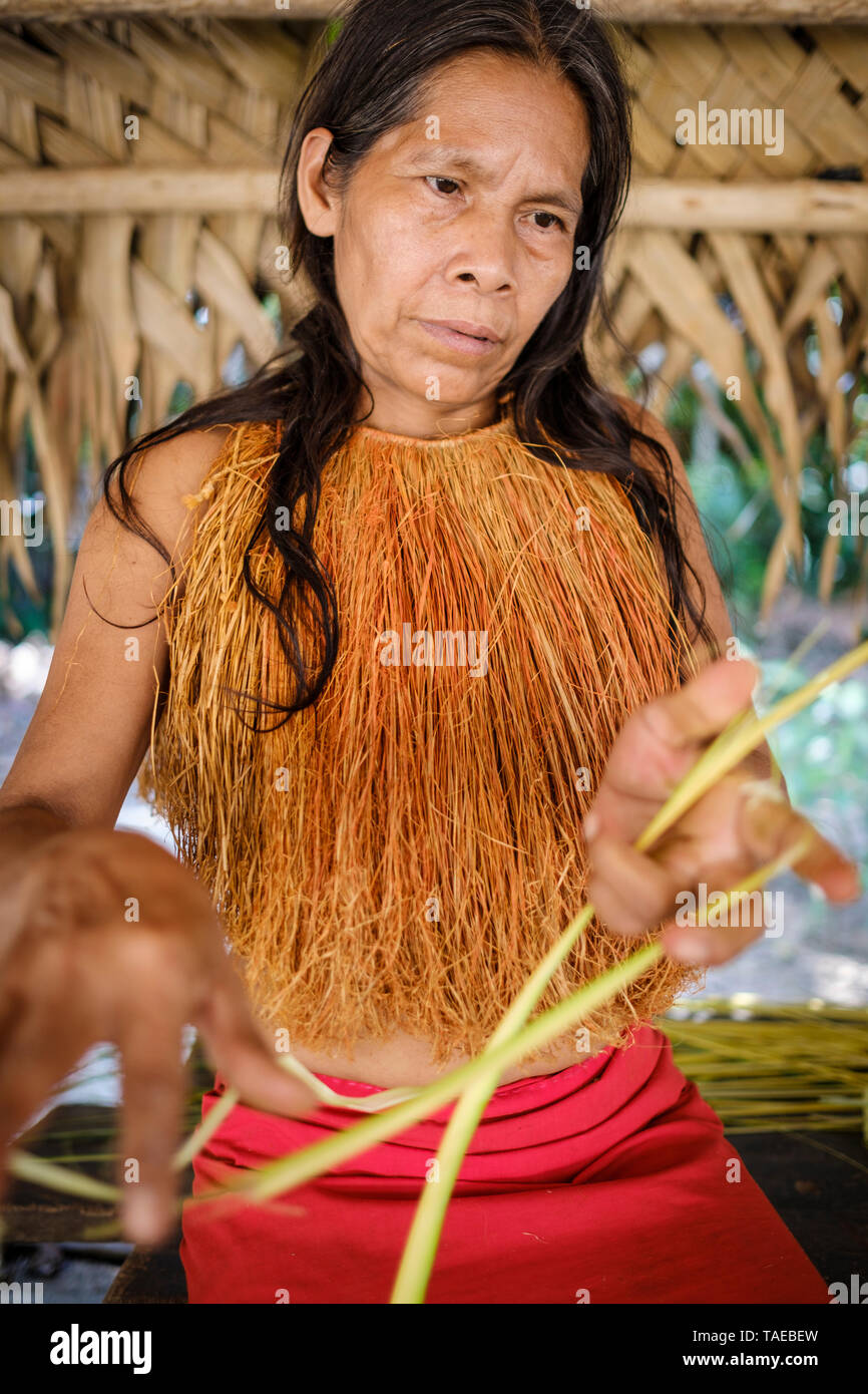 Woman of Yagua tribe making ornaments on the Yagua village of Nuevo ...