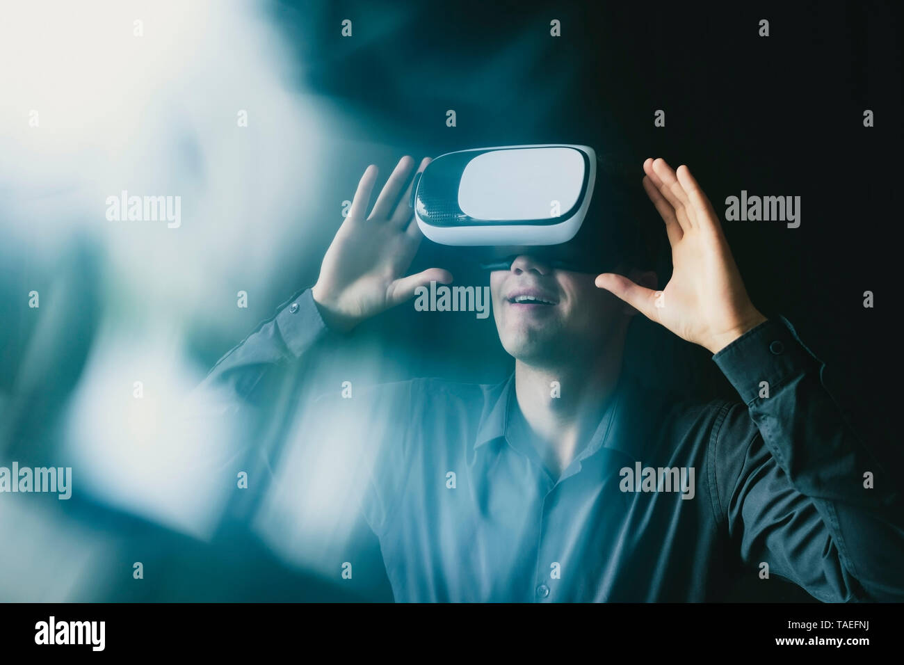 Composite image of a man wearing a VR headset interacting with a ...