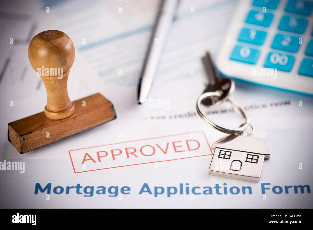 An approved Mortgage loan application form with house key and rubber ...