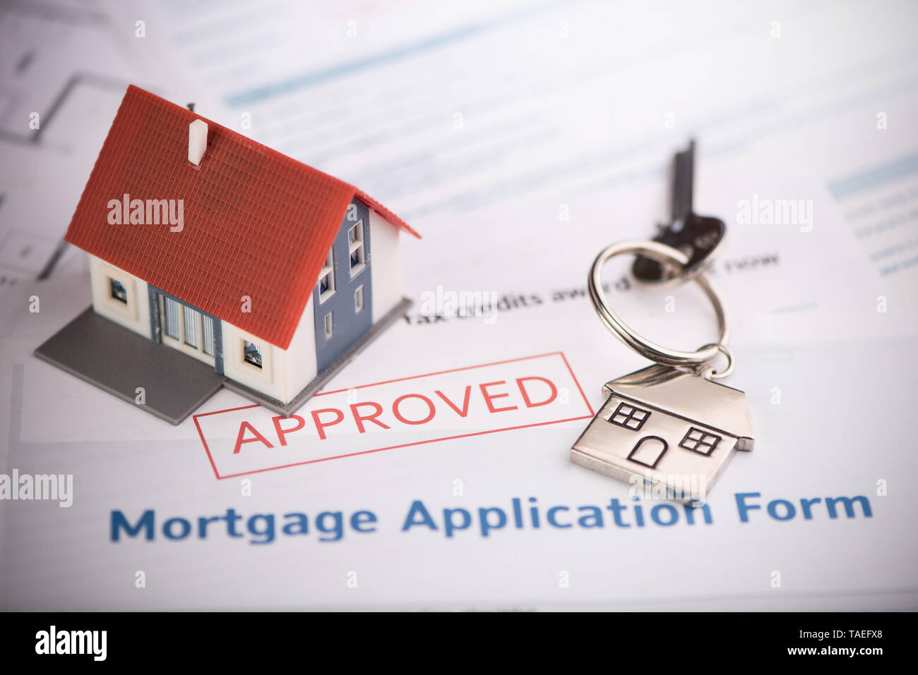 An approved Mortgage loan application form with house key and rubber ...