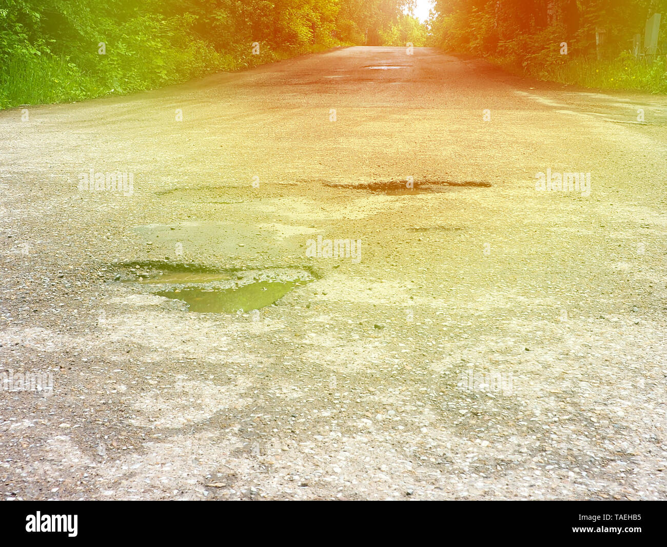 large pits with stones on the asphalt road Stock Photo - Alamy