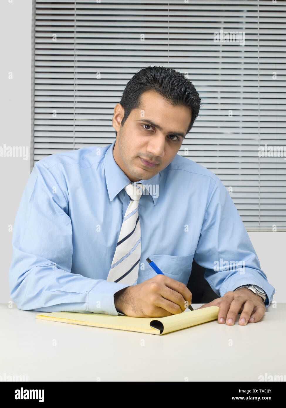 CORPORATE EXECUTIVE writing notes while working on his desk Stock Photo ...