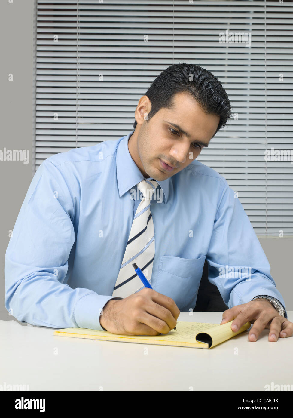 CORPORATE EXECUTIVE writing notes while working on his desk Stock Photo ...
