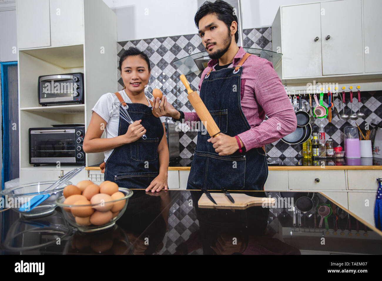 Happy and Smiling young couple cooking food in the kitchen at home ...
