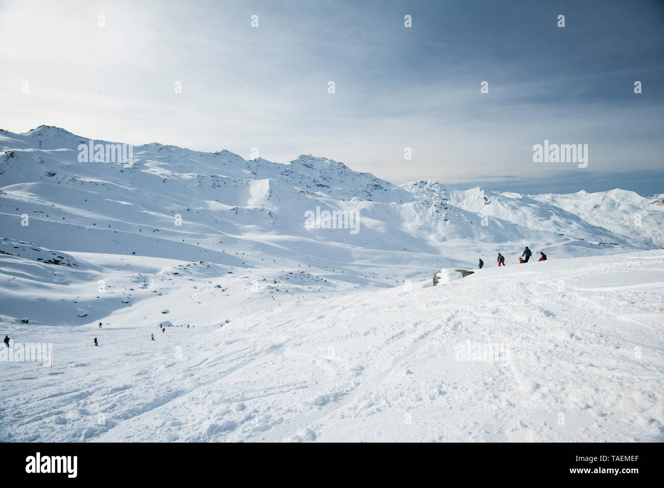 Panoramic landscape view with off piste skiers going down a slope in ...