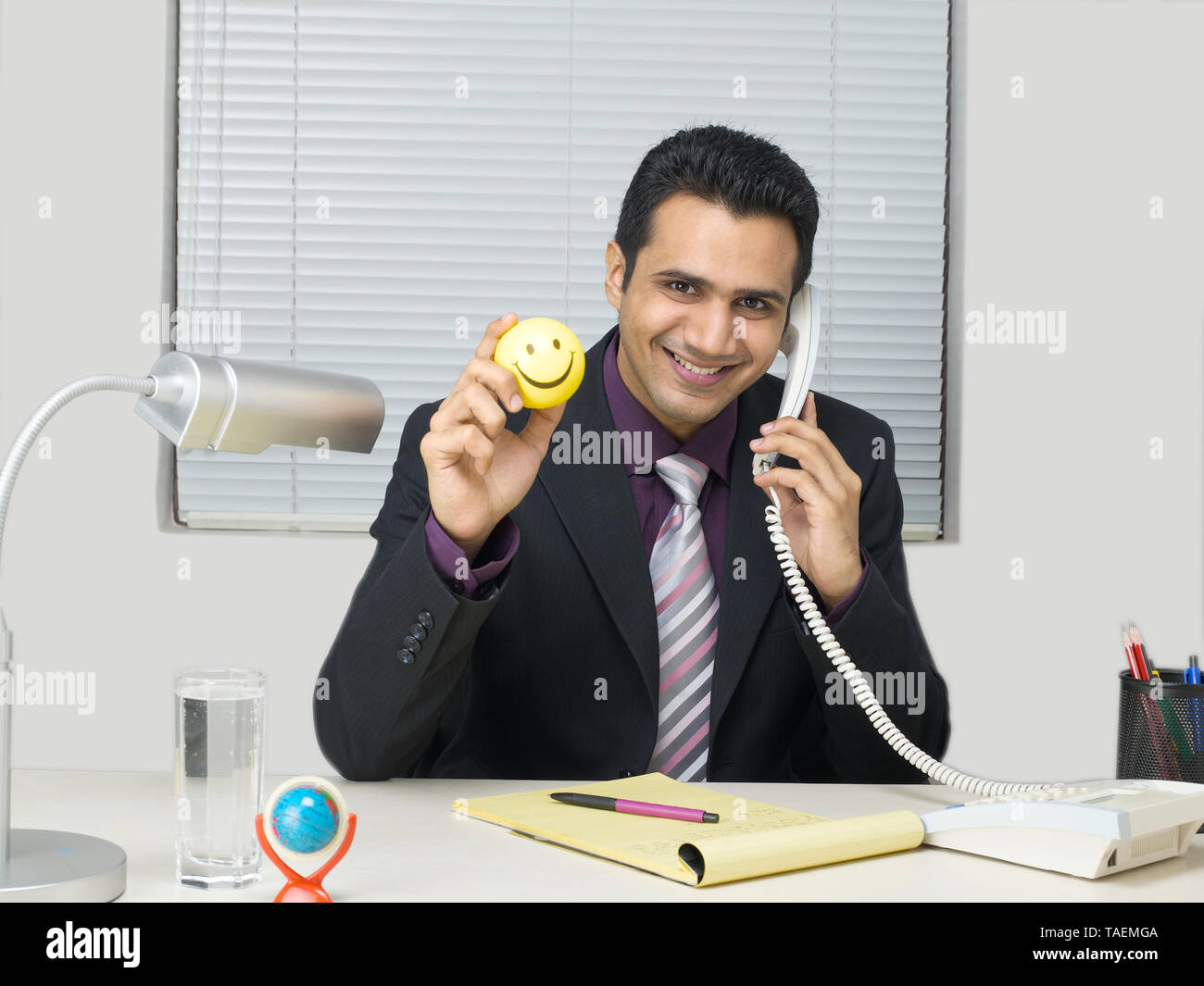 PORTRAIT OF A CORPORATE EXECUTIVE HOLDING A SMILEY BALL Stock Photo - Alamy