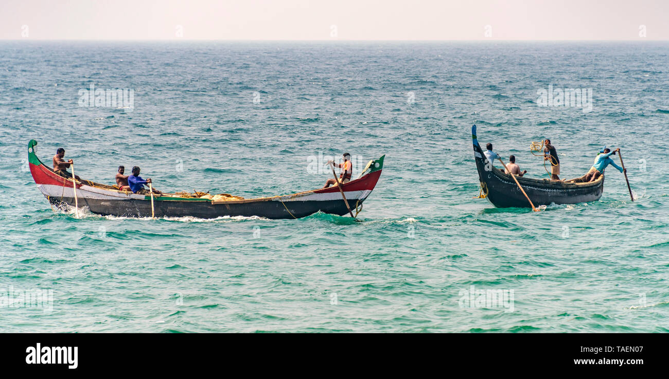 Horizontal view of local fishermen rowing out to sea in Kerala, India ...