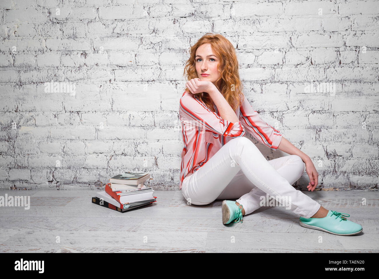 happy student girl with red hair and freckles prepares homework ...