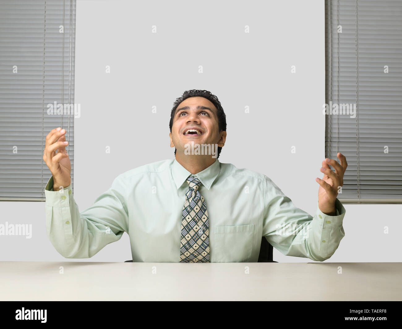 CORPORATE EXECUTIVE EXPRESSING JOY WHILE WORKING ON HIS DESK Stock ...
