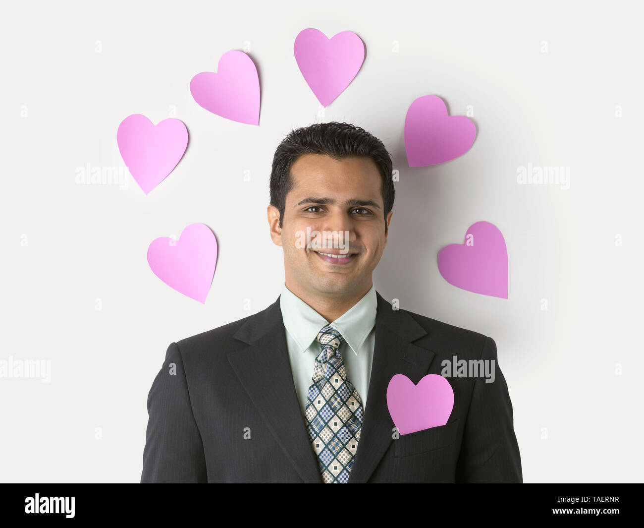 PORTRAIT OF CORPORATE EXECUTIVE WITH GRAPHIC CUT OUTS OF A HEART ...