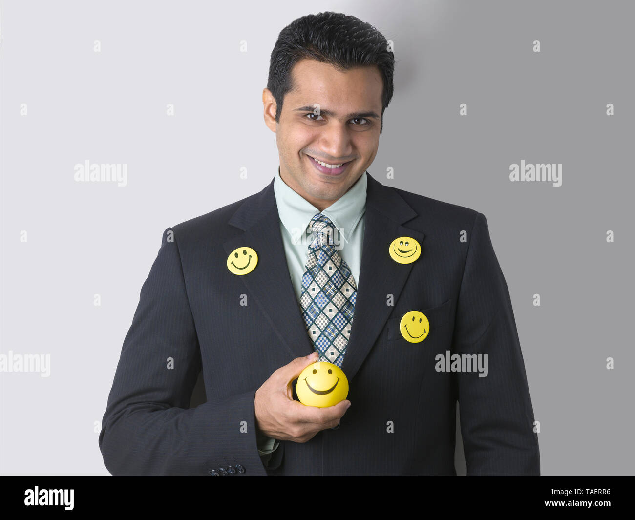 PORTRAIT OF A CORPORATE EXECUTIVE HOLDING A SMILEY BALL WITH SMILEY ...