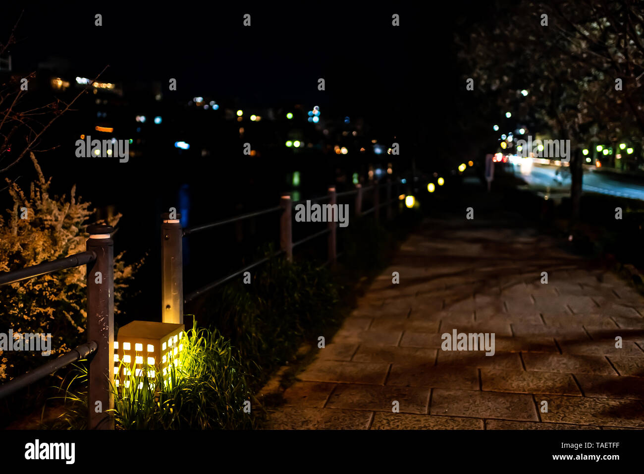 Kyoto, Japan illuminated lantern on sidewalk path along Kamo river at ...